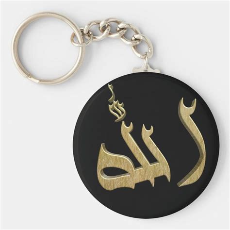 A Keychain With An Arabic Calligraphy In Gold On A Black Back Ground