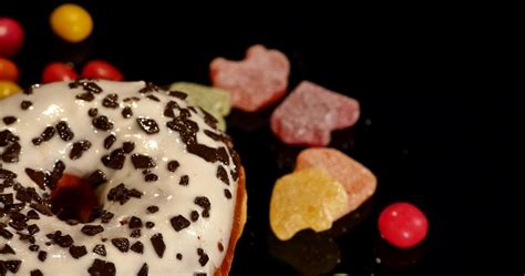 초콜렛 결빙 또는 뿌리 줄무늬 카라멜 사탕 검은 배경에 건포도 또는 땅콩이 있는 다채로운 당의 정가 있는 흰색 유약 도넛 0명에 대한 스톡 사진 및 기타 이미지 Istock