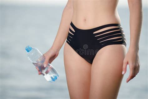 Stomach Beautiful And Sporty Body Of Woman In Bikini With Bottle Of