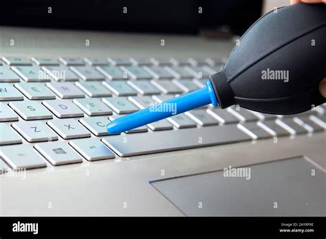 Closeup Shot Of Female Hand Sweeping Dust From Laptop Keyboard Using Air Bulb Stock Photo Alamy