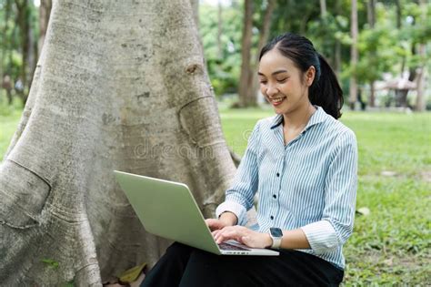 Young Business Woman Digital Nomad Working Outdoors On Laptop In A Park