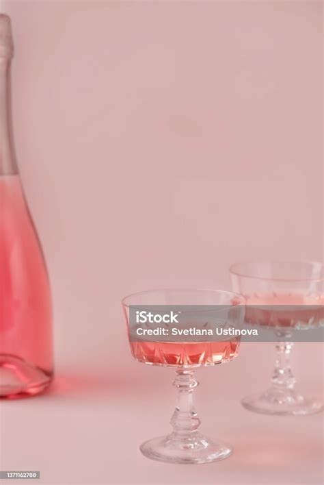 파스텔 핑크 배경에 크리스탈 안경 2개와 장미 스파클링 와인 또는 샴페인 한 병 복사 공간이 있는 창의적인 구성 0명에 대한 스톡 사진 및 기타 이미지 Istock