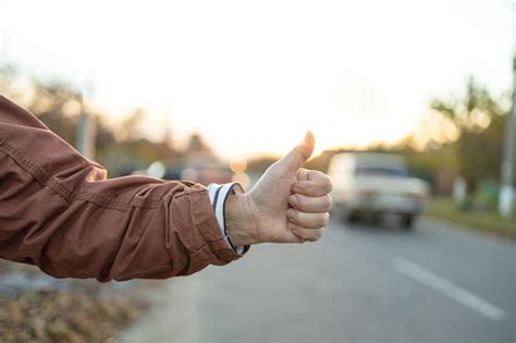 여성의 손과 히치하이크 표지판 도시에서 자동 정지로 여행 여자는 자동차 엄지 손가락을 중지하려고합니다 모험과 관광 컨셉 히치
