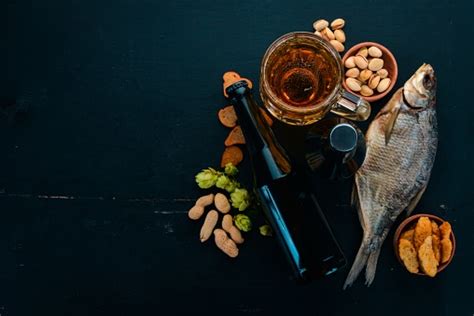 맥주와 스낵 소금에 절인된 크래커 말린 물고기 칩 견과류 땅콩 피스타치오 에 검은 나무 배경 텍스트에 대 한 여유 공간입니다 최고의 볼 수 있습니다 0명에 대한 스톡 사진