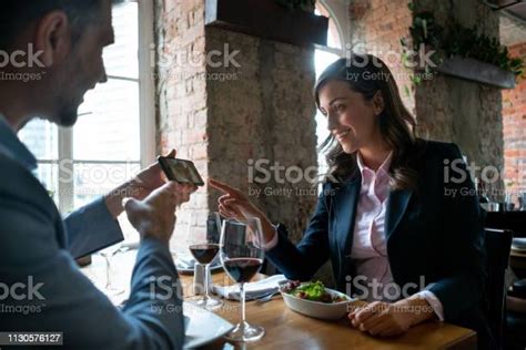 쾌활 한 남자가 보여주는 파트너 사진 그는 그냥 했다 그의 음식과 여자는 웃 고 그것을 가리키는 레스토랑에 대한 스톡 사진 및 기타 이미지 Istock