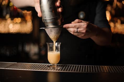 남성 바텐더는 체를 통해 스틸 셰이 커에서 맛 있는 칵테일을 붓는 각얼음에 대한 스톡 사진 및 기타 이미지 각얼음 갈색 검은색 Istock