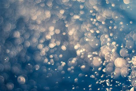 흐릿한 조명 배경의 추상적인 노란 Bokeh 물결 모양 푸른 물 배경 위에 소프트 포커스 Bokeh 빛 효과 디자인 프로젝트에