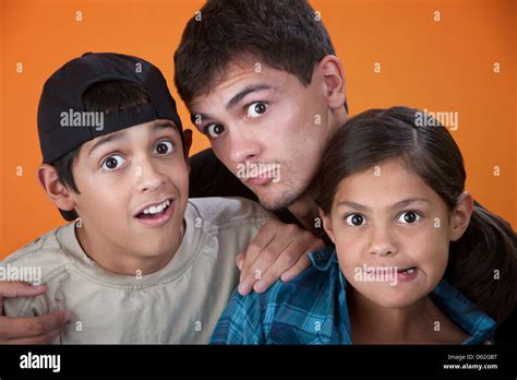 Elder brother with two younger siblings making faces Stock Photo - Alamy