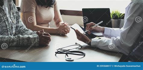 Doctor Or Physician Writing Diagnosis And Giving A Medical Prescription To Female Patient Stock