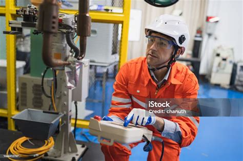 백인 기술자 엔지니어 남자는 공장에서 기계 팔 로봇을 확인하는 원격 제어를 사용합니다 전기 연료 및 전력 생산에 대한 스톡 사진 및 기타 이미지 전기 연료 및 전력 생산