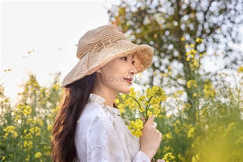 짚 모자를 입고 긴 머리를 가진 아름 다운 여자 유채 필드에서 웃고 사진 무료 다운로드 Lovepik