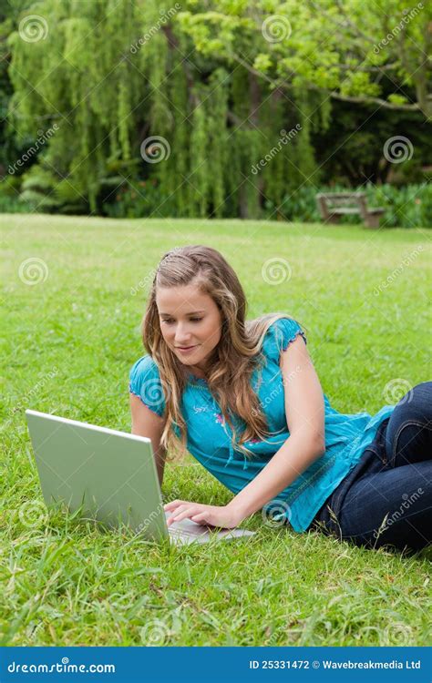 Girl Lying On Her Side While Working On Her Laptop Stock Photo Image