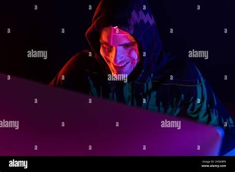 smiling hacker with reflection of charts using computer isolated on