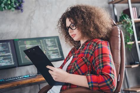 Young Female Programmer Working From Home In A Casual Workspace Reviewing Programming Documents