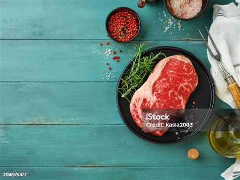 검은 접시에 생 쇠고기 스테이크 와 후추 소금 로즈마리 올리브 오일 와 오래 된 복고풍 테이블 배경 요리 조리법 평면도 0명에 대한 스톡 사진 및 기타 이미지 Istock