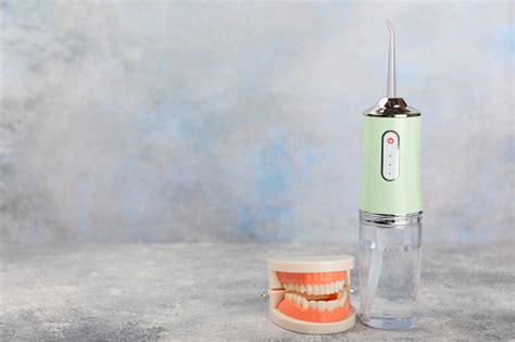 파란색 배경에 전자 구강 세정기 칫솔 페이스트 치실 및 구강 세정제 구강 위생을위한 치과 도구 전기 치간 청소기 치과용 물 샤워 구강 관리 개념입니다 0명에 대한 스톡 사진