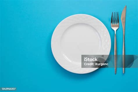 파란색 배경에 빈 흰색 접시 포크와 칼 맨 위 보기입니다 텍스트 공간입니다 빈 접시에 대한 스톡 사진 및 기타 이미지 빈