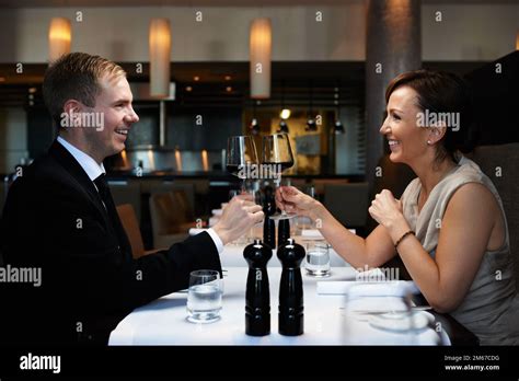 Giving Themselves A Toast A Couple Having Dinner In A Restaurant Stock Photo Alamy