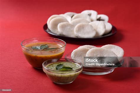 빨간 배경에 삼바와 코코넛 처트니를 곁들인 이들리 인도 남부에서 가장 좋아하는 음식 라바 Idli 또는 세몰리나 또는 라바가