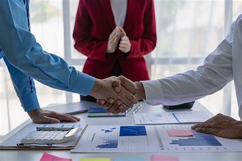 이 개념은 새로운 동료 팀을 맞이하고 사업가들은 회의 중에 악수하여 두 사람을위한 계약과 성공적인 비즈니스 협력에 서명합니다 회사 악수에 대한 스톡 사진 및 기타 이미지