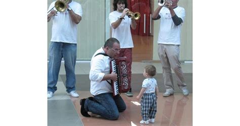 Ангел Заберски на колене с акордеон пред детенце в мол