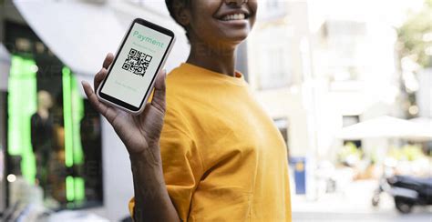 Smiling Woman Showing Smart Phone With QR Code Stock Photo