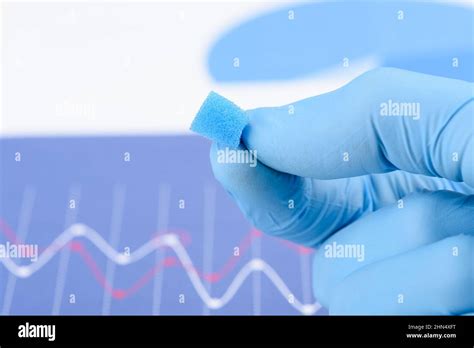 Blue Porous Foam Material In Scientist Fingers In Laboratory Research