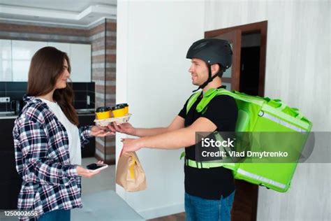 음식 배달 남자는 젊은 여자 집에 커피와 종이 가방을 가져왔다 그는 자전거나 자전거를 타고 헬멧을 쓰고 왔습니다 2명에 대한 스톡 사진 및 기타 이미지 Istock