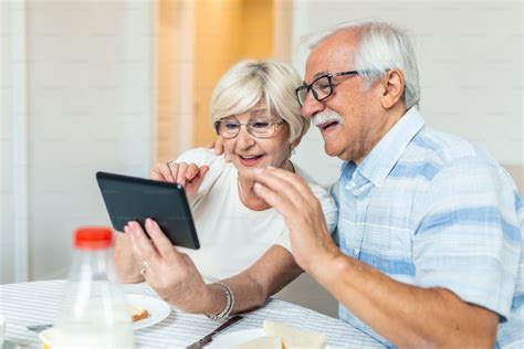 태블릿으로 셀카를 찍는 노부부 태블릿을 사용하여 친구나 가족과 화상 통화를 하는 노부부 늙은 부부는 태블릿의 비디오 연결을 통해 온라인으로 이야기하고 있습니다 사진