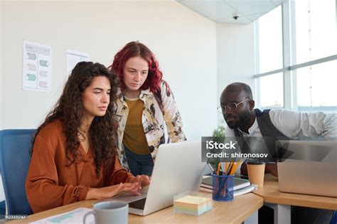 프로젝트를 통해 작업하는 동안 노트북 화면을 보는 두 명의 젊은 사업가 3 명에 대한 스톡 사진 및 기타 이미지 3 명 일함 주름장식 Istock