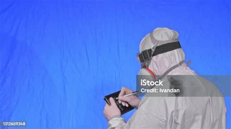 호흡보호구의 과학자 바이러스학자는 스타일러스가 있는 태블릿 컴퓨터에 글을 씁니다 보호 의료 마스크를 착용 하는 남자 크로마 키 블루 크로마 키에 대한 스톡 사진 및 기타