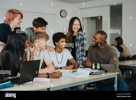 Happy Male And Female Students With Non Binary Person Discussing With
