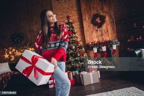 사랑 스럽다 좋은 여자 빨간 프린트 스웨터를 입고 크리스마스 선물 상자를 즐기고 휴일을 즐기고 실내 아파트 방을 즐긴다 12월에 대한 스톡 사진 및 기타 이미지 Istock