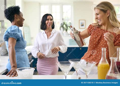 Three Mature Female Friends At Home Having Fun Mixing Cocktails