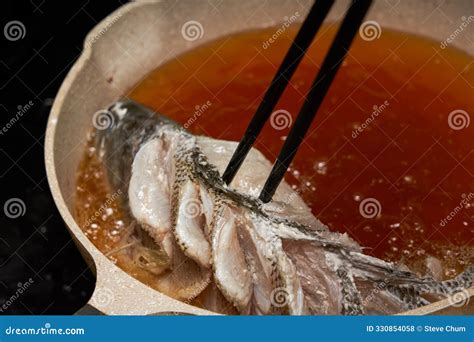 A Chef In The Kitchen Is Making Fried Fish Frying A Whole Fish Stock