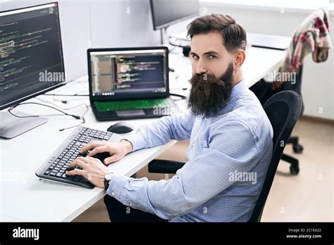 Serious Computer Programmer Developer Working In It Office Sitting At Desk And Coding Working
