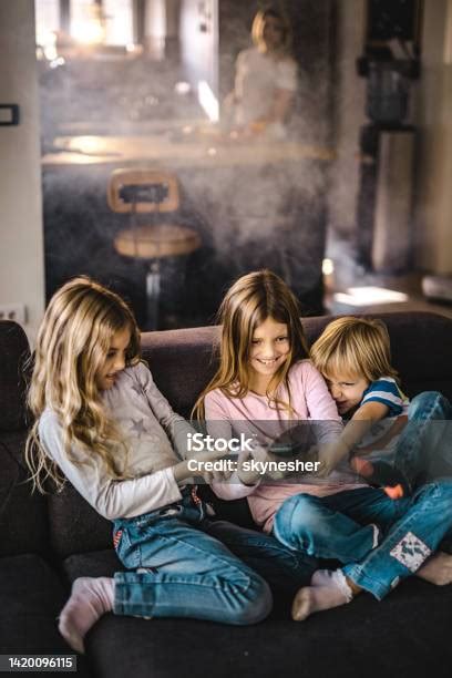 Small Siblings Fighting Over A Remote Control In The Living Room Stock