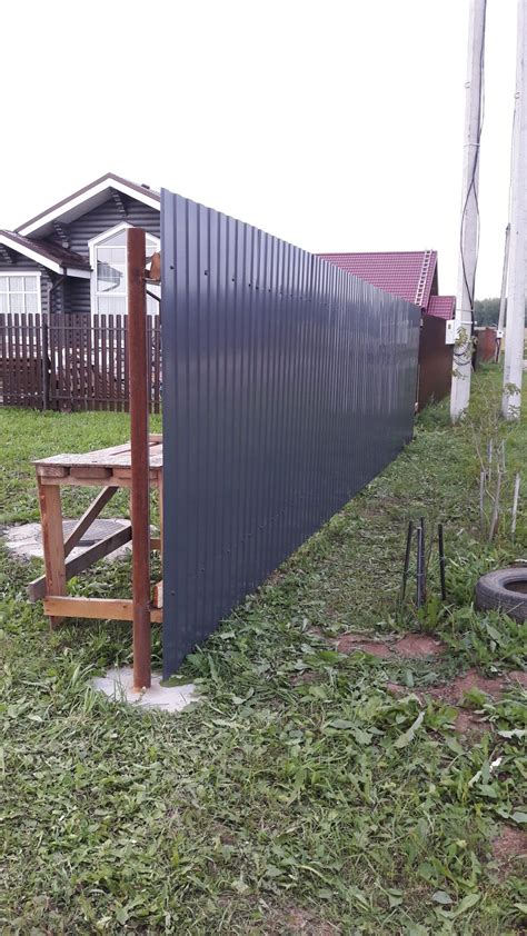 Современный забор на фоне зеленого поля