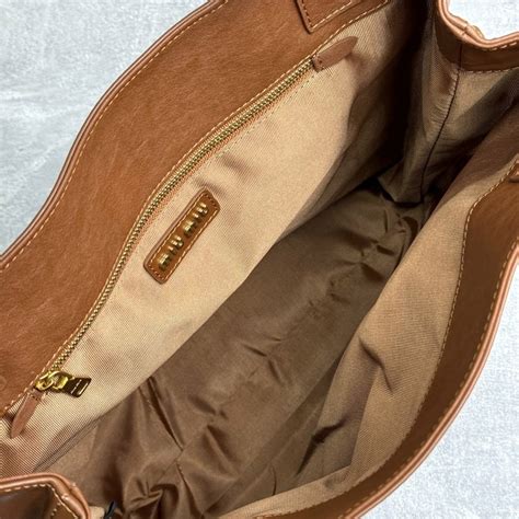 Купить Кожаная сумка хобо Miu Miu с логотипом по цене от 11 900 р в