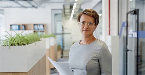 사무실에 서서 문서를 들고 있는 동안 카메라를 보고 있는 성인 여성 관리자의 허리 위로 초상화 복사 공간 사진 Unsplash의 성인 이미지