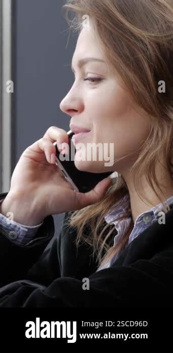 Smiley Young Adult Caucasian Businesswoman Conducting Remote Business Conversation Using Phone