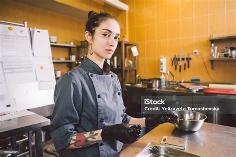 지배 직업 그리고 요리 생 과자입니다 젊은 백인 여자 라운드 초콜릿을 준비 하는 레스토랑의 주방에서 제빵의 문신과 검은 장갑과 유니폼에서 수 제 트 러 플 캔디 가정 주방에