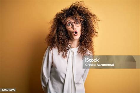 곱슬 머리와 피어싱 셔츠와 안경을 입고 젊은 아름다운 갈색 머리 여자는 두려워 깜짝 표정 두려움과 흥분 얼굴충격 감정에 대한