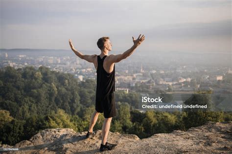 높은 언덕에서 휴식을 취하는 잘 생긴 근육 질의 남자의 뒷모습 팔을 뻗어 서 건강한 생활방식에 대한 스톡 사진 및 기타 이미지 건강한 생활방식 근육질 체격 남성