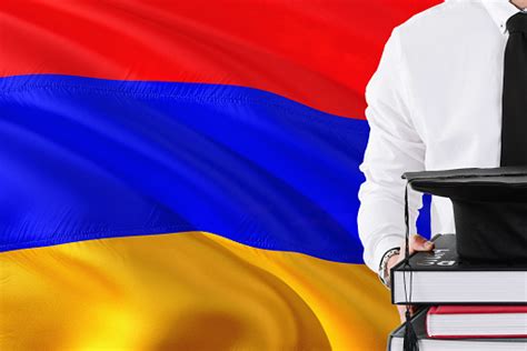 성공적인 아르메니아 학생 교육 개념입니다 책과 아르메니아 국기 배경 위에 졸업 모자를 들고 교사 교육 관련 직업에 대한 스톡 사진 및 기타 이미지 Istock