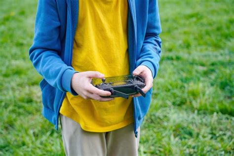 The Boy Controls The Flight Of The Quadcopter Using The Remote Control Stock Image Image Of