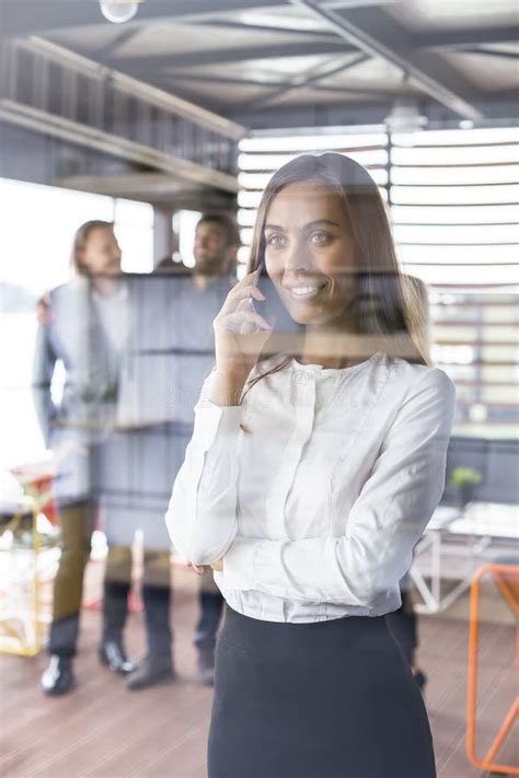 Beautiful Businesswoman Using A Cell Phone In Her Office Stock Image