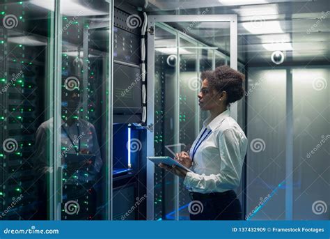 Female Technician Works On A Tablet In A Data Center Stock Image