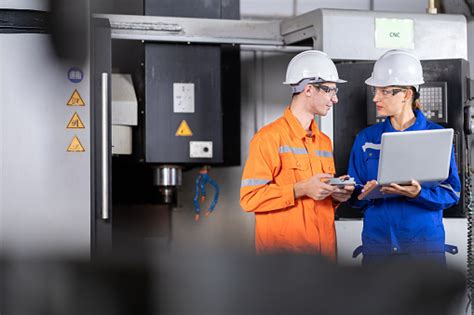 Cnc 기계 앞에서 논의하는 노트북 엔지니어를 들고 있는 백인 백인 남성과 여성은 모두 공장에서 서로를 바라봅니다 자랑스러움에 대한 스톡 사진 및 기타 이미지 Istock