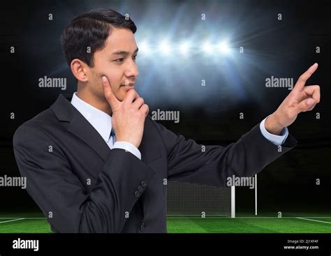 asian businessman touching an invisible object against soccer field